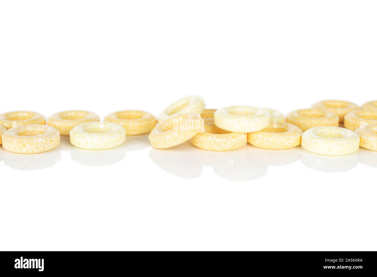 Lot of whole round pale yellow candy in row isolated on white ...
