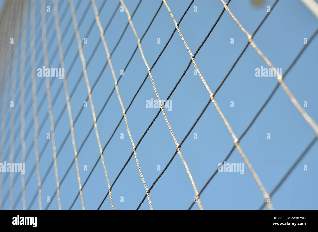 Netting against blue sky, square shapes and wavy lines Stock Photo - Alamy