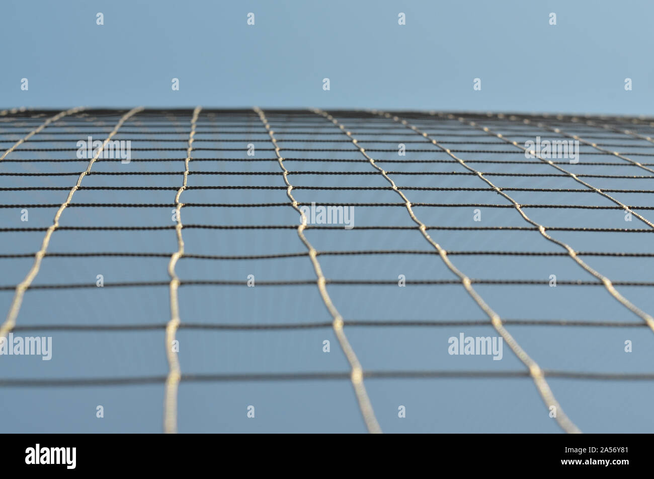Netting against blue sky, square shapes and wavy lines Stock Photo - Alamy