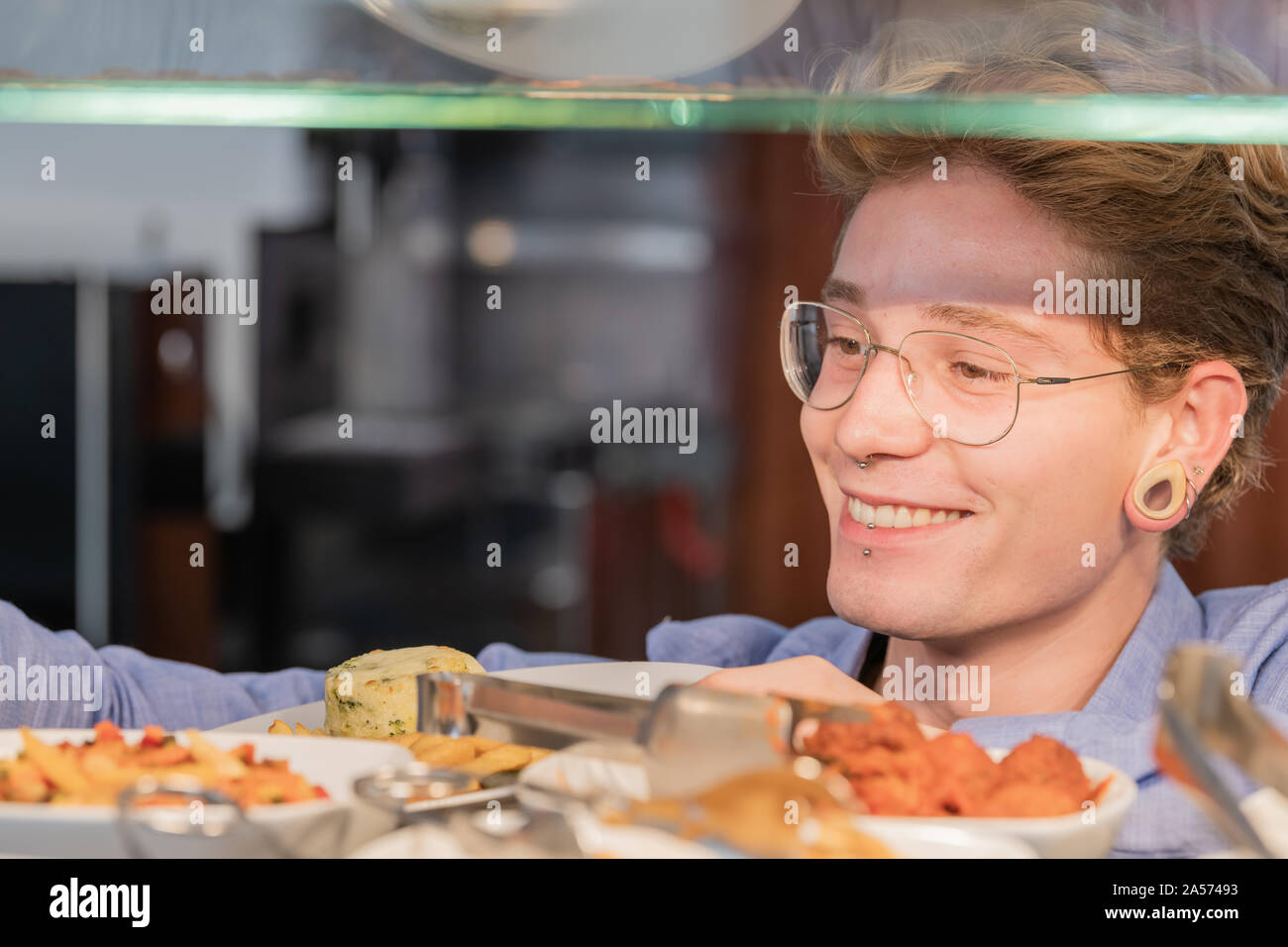 Boy looking at the food in front of his face in a smiling way with ...
