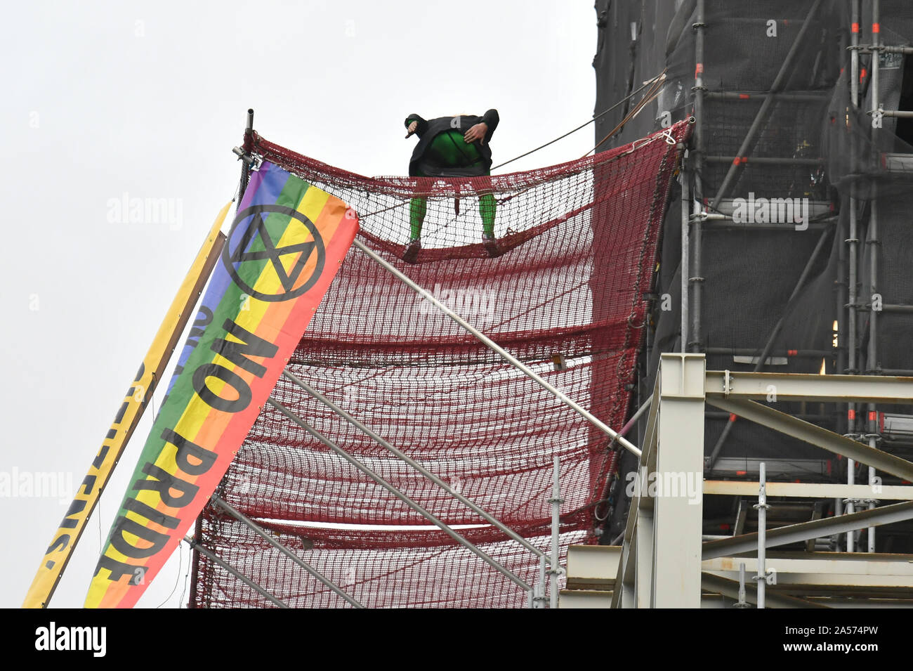 An Extinction Rebellion protester who has scaled the scaffolding ...