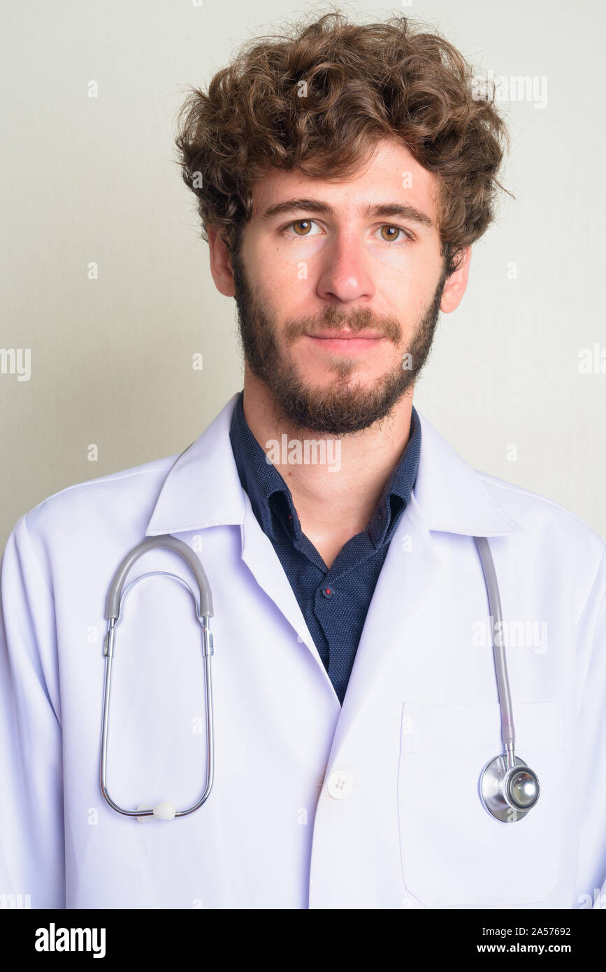 Face of young bearded man doctor with curly hair Stock Photo - Alamy