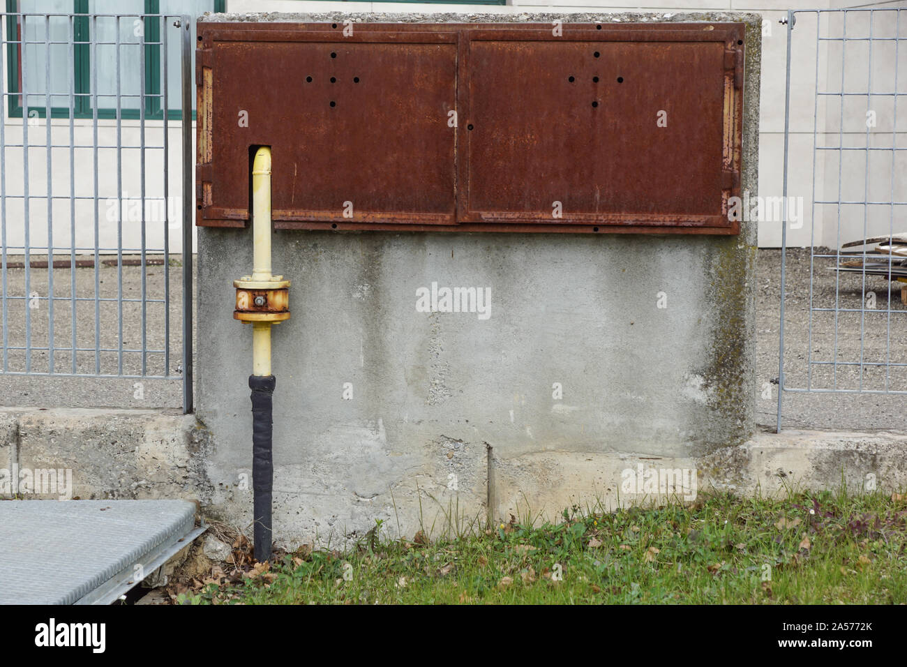 Old gas gate of yellow colour is on a pipe and blocks a pipe. The ...