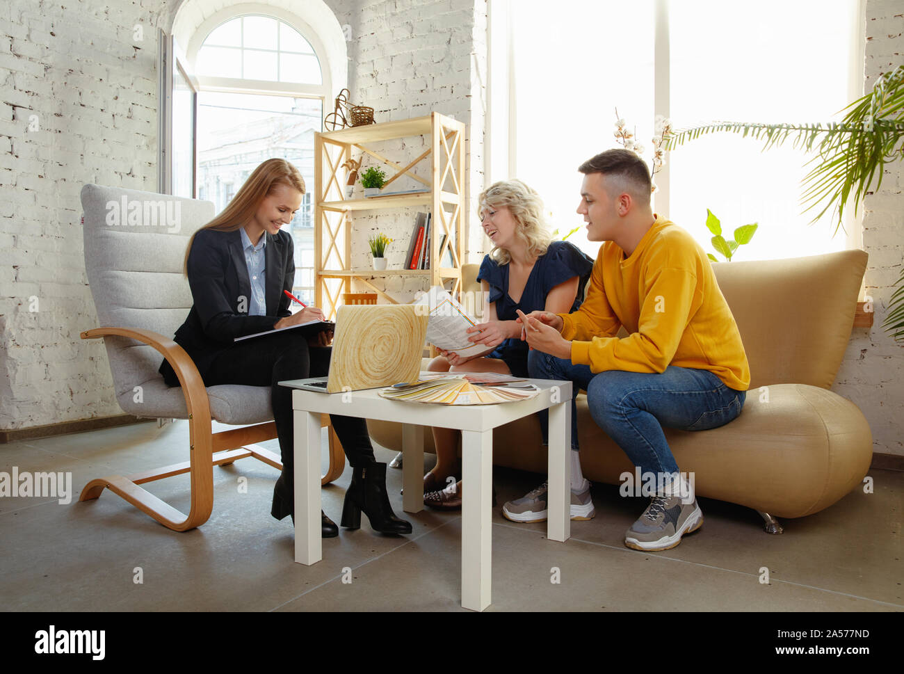 Interior designer working with young couple. Lovely family and ...