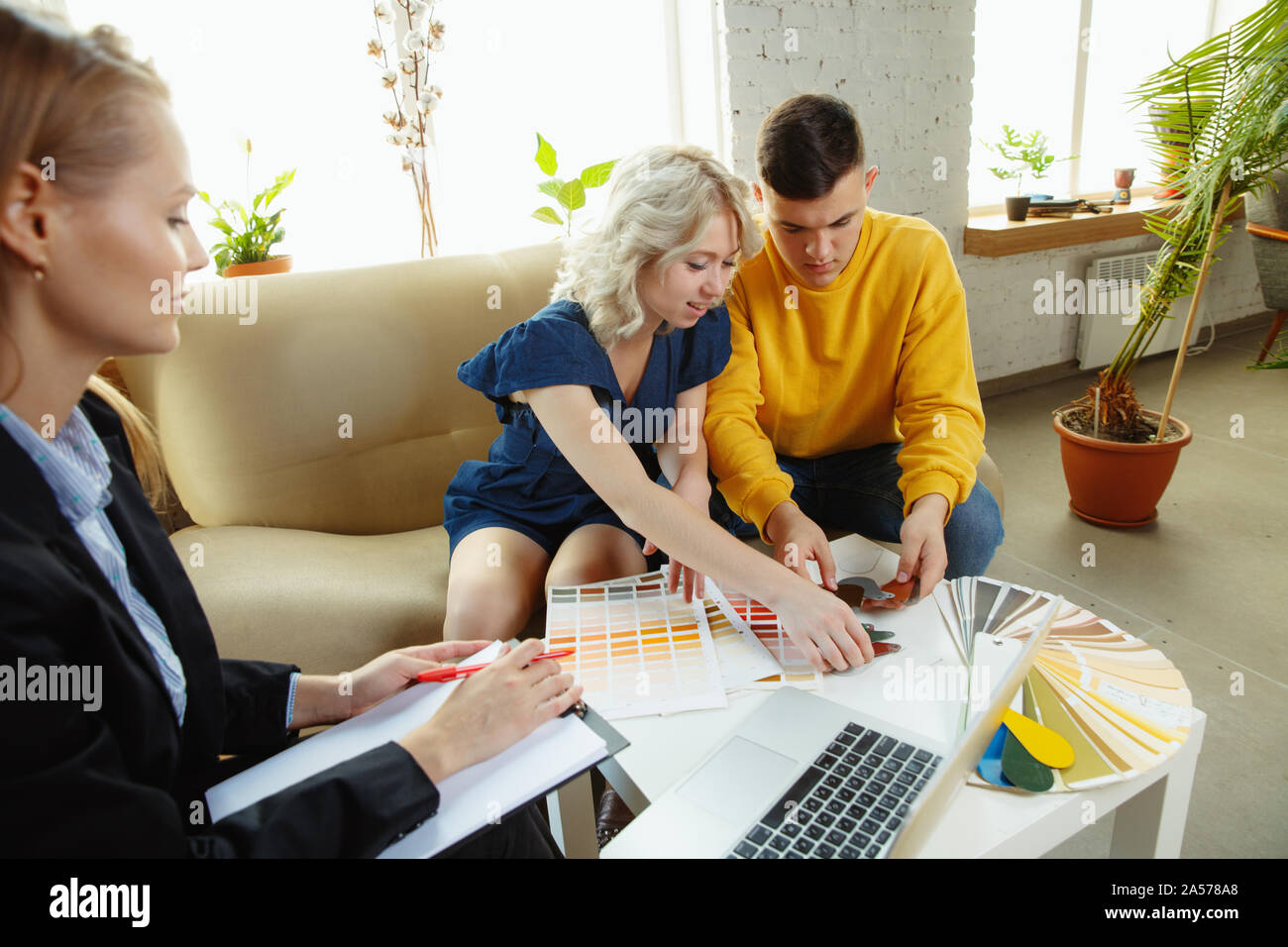 Interior designer working with young couple. Lovely family and ...