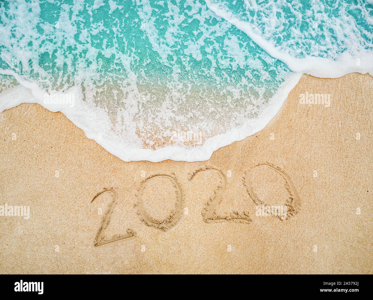 Happy New Year 2020 written on seashore sand at sunrise concept ...
