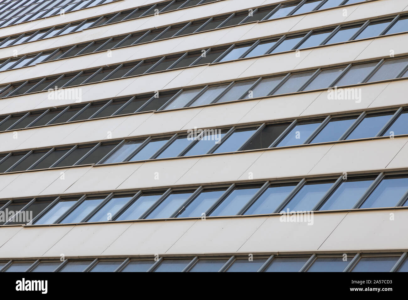 Ground view of high modern building with many windows and blue sky ...
