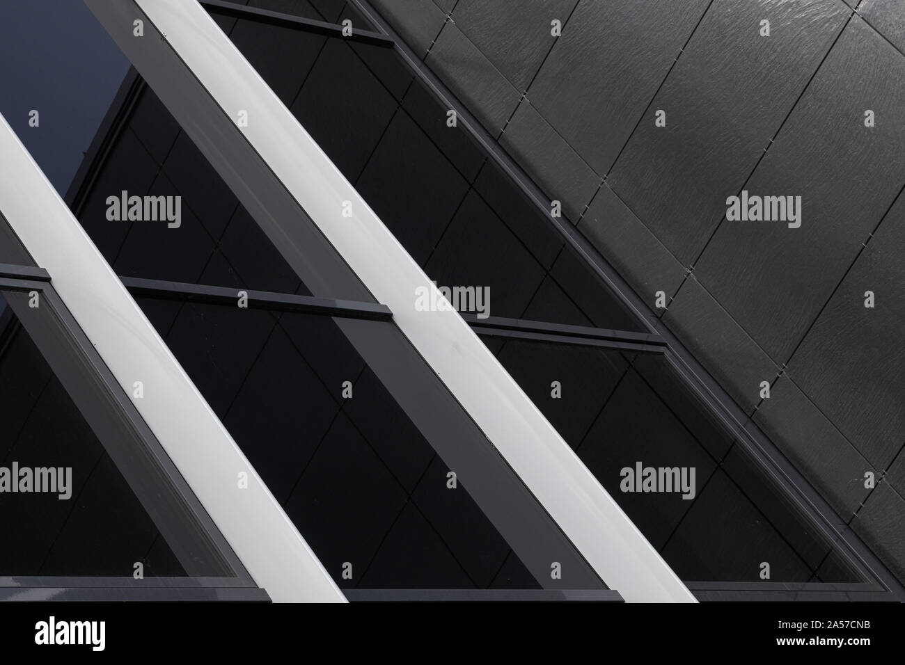 close-up of black glass wall and black wall covered with rugged tiles ...