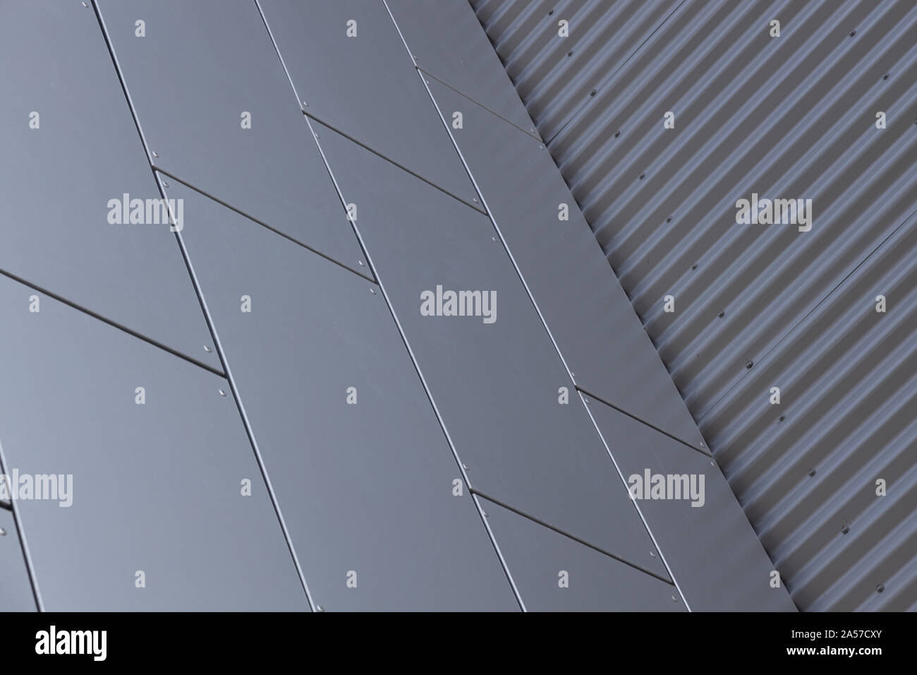 Bottom view of corner of building - junction of grey smooth tiled wall ...