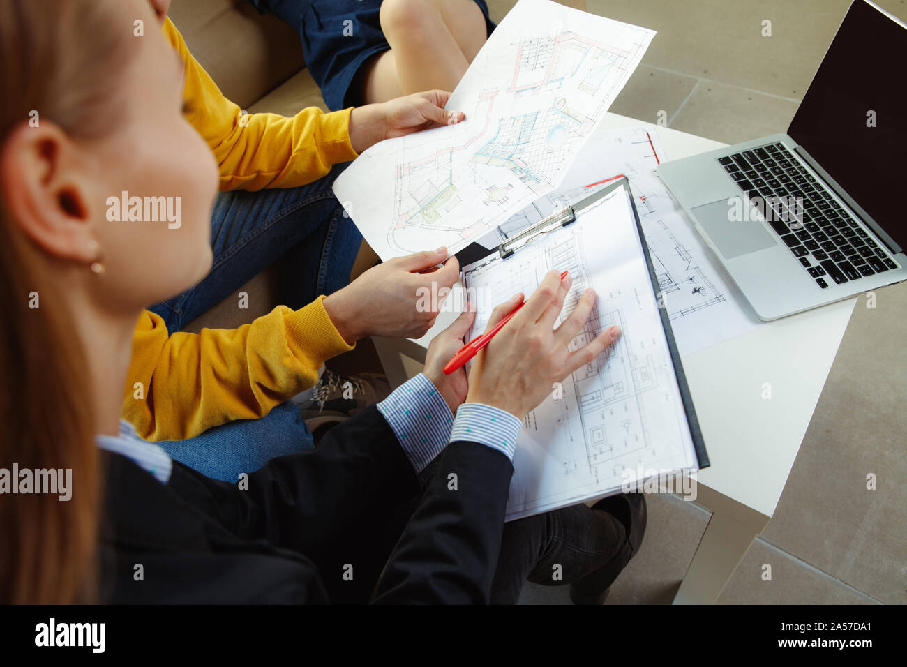 Interior designer working with young couple. Lovely family and ...