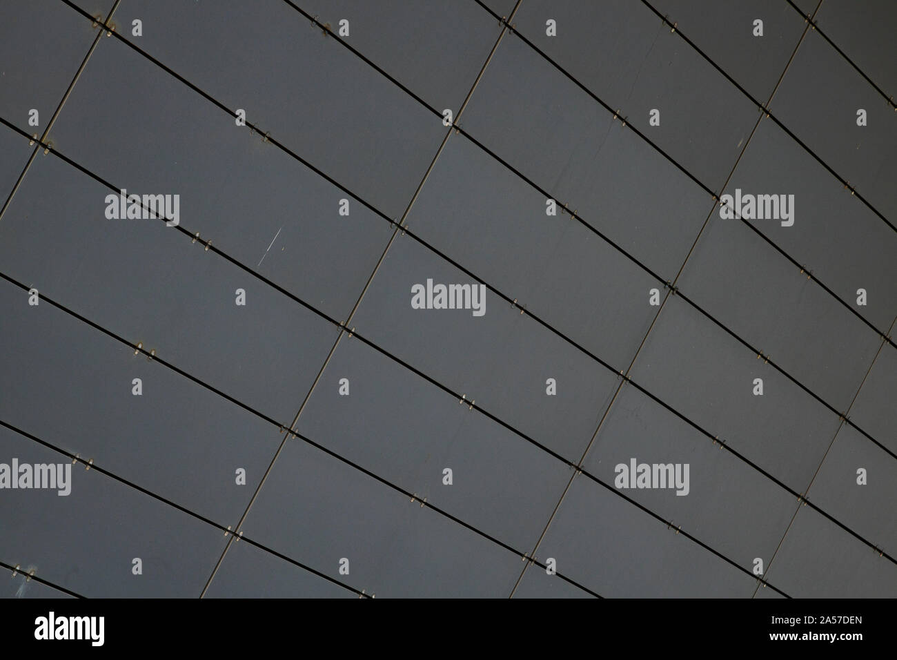 Grey metal wall of a building made of small metal rightangled sheets ...
