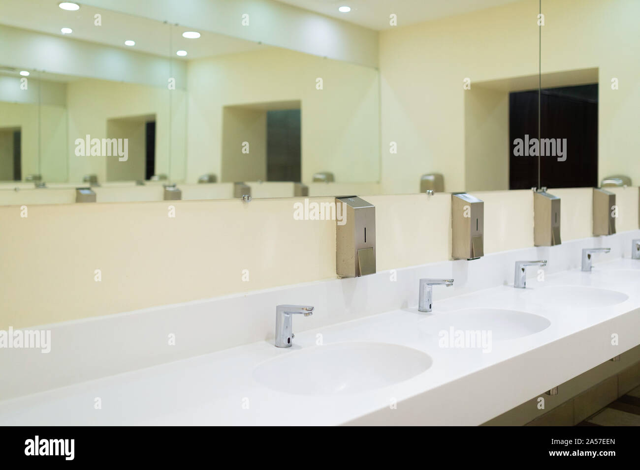 Diagonal view of cutting-edge public toilet room with white ceramic ...
