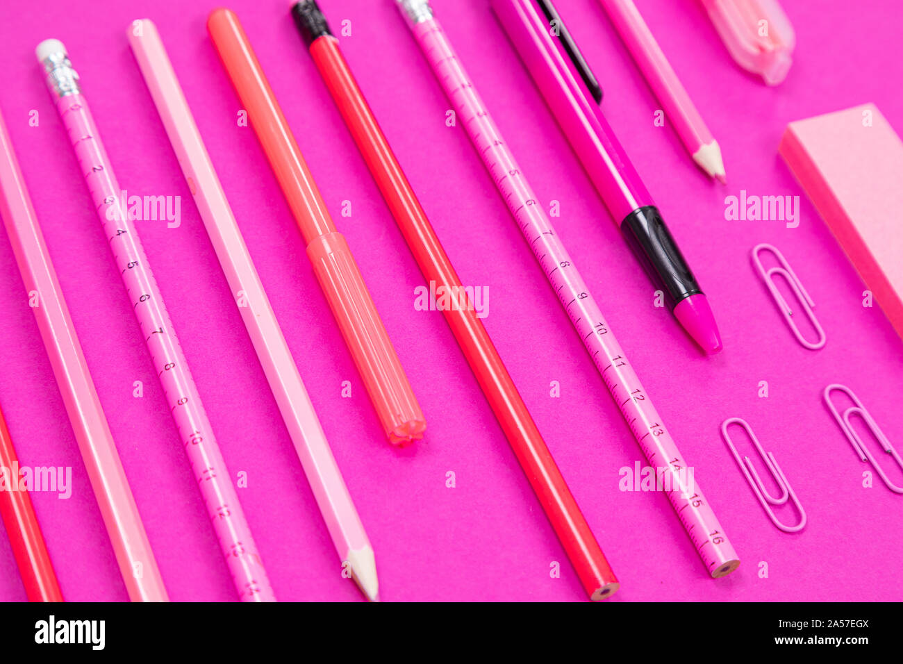 Close up of straightly arranged group of pink color writing equipment ...