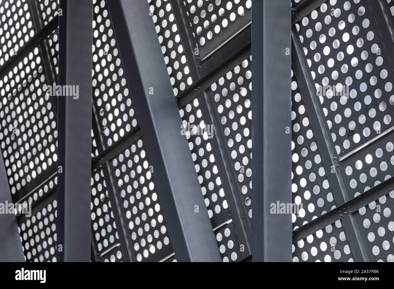 Metal surface with round openings bearing against iron girders Stock ...