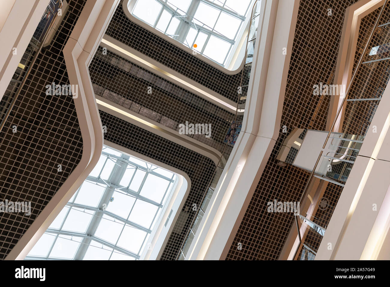 Bottom, diagonal view of black and golden tiled hall with big window in ...