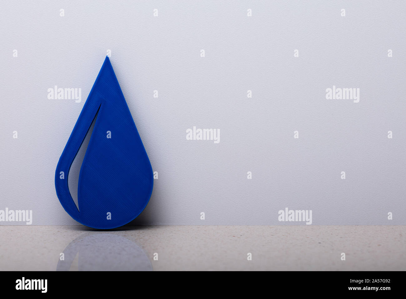 Close-up Of A Water Drop Symbol Leaning On White Wall Stock Photo - Alamy