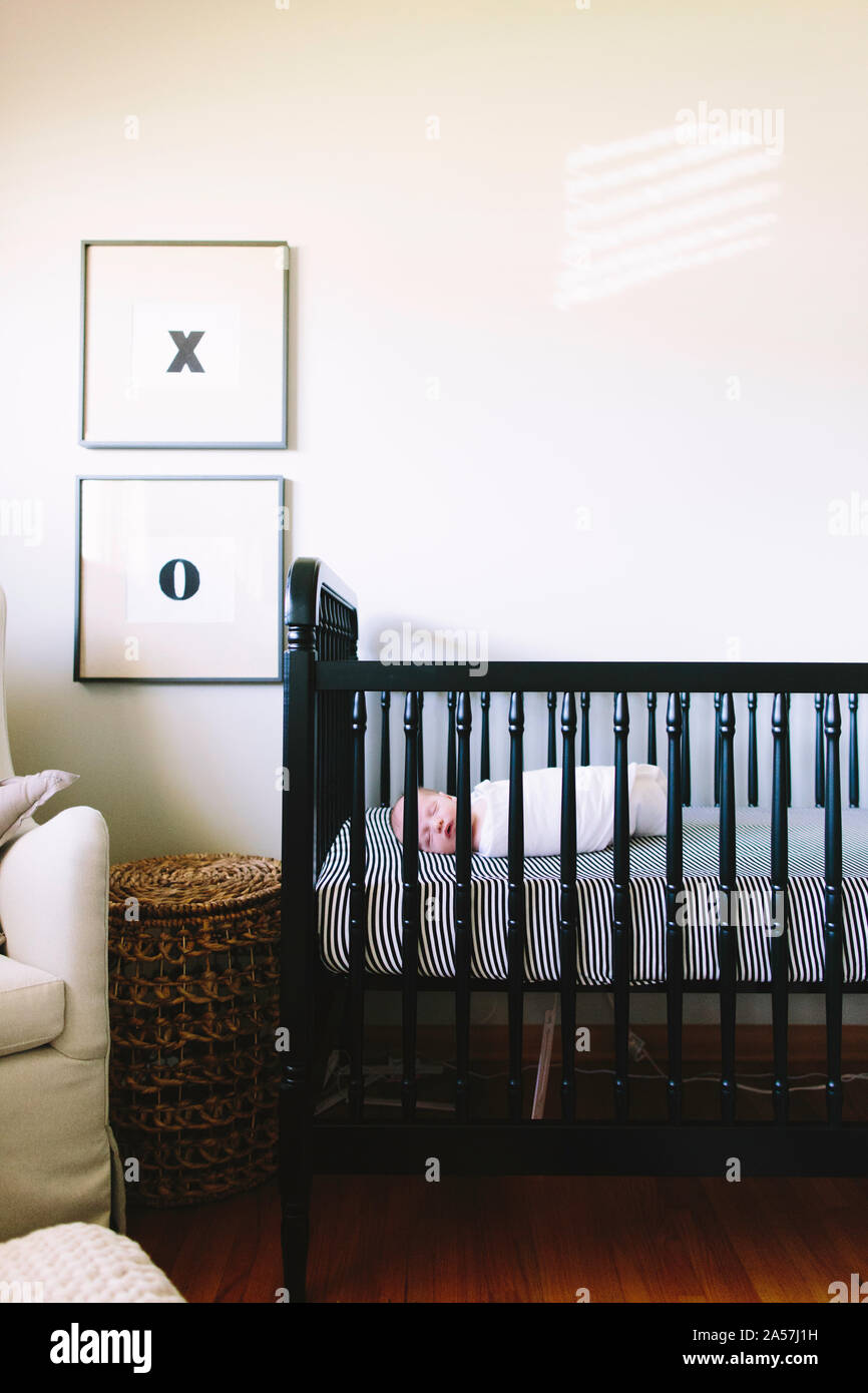 A baby boy sleeping in his crib in a modern nursery Stock Photo - Alamy