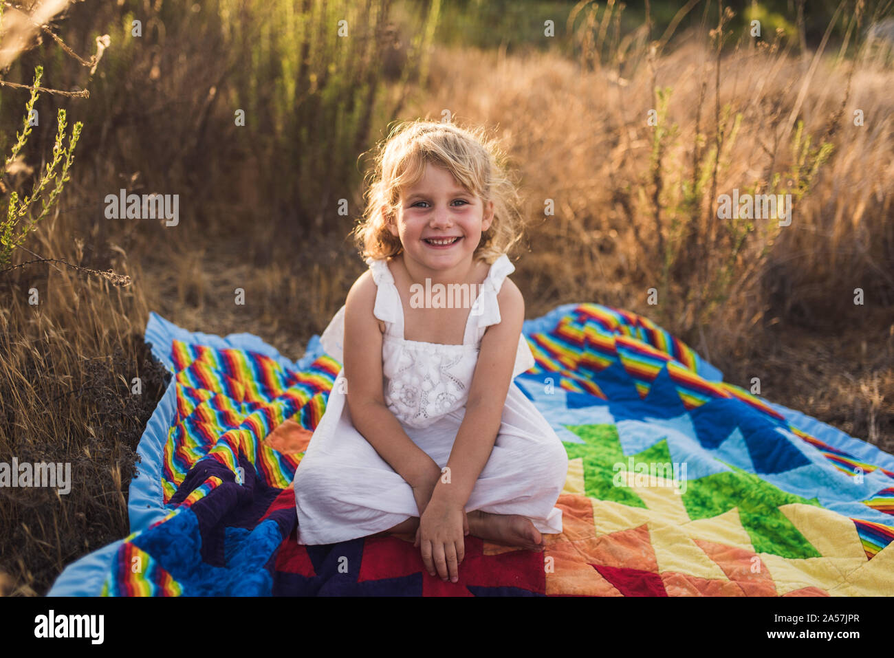 Barefoot 4 yr old girl sitting on bold blanket in nature setting Stock ...