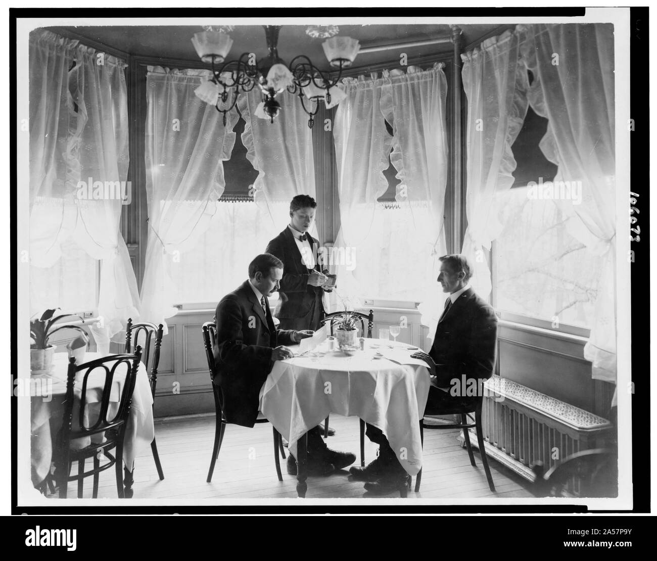 Waiter taking an order from two men in restaurant Stock Photo - Alamy