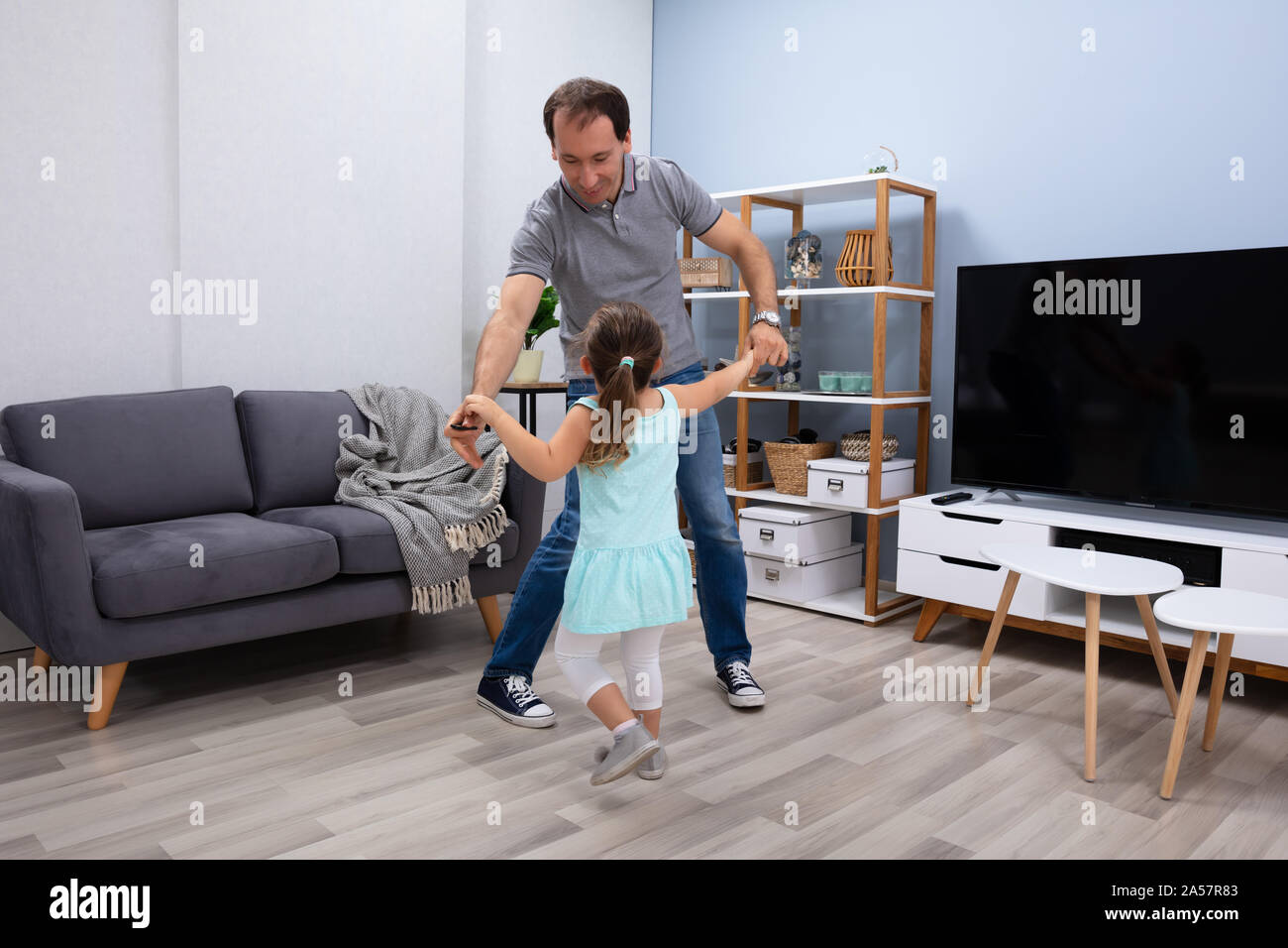 Father And Daughter Enjoying Dancing Together At Their Modern Home ...
