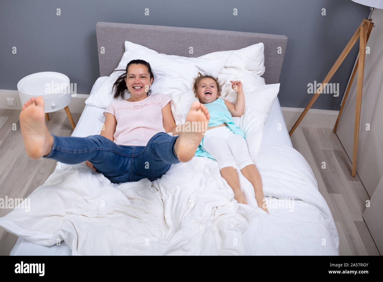 An Overhead View Of Happy Mother And Daughter Having Fun On Bed Stock