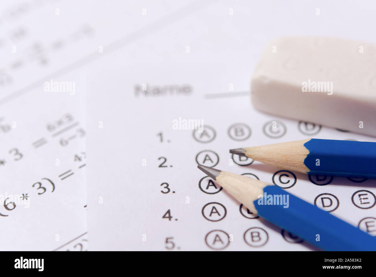 Pencil and eraser on answer sheets or Standardized test form with ...