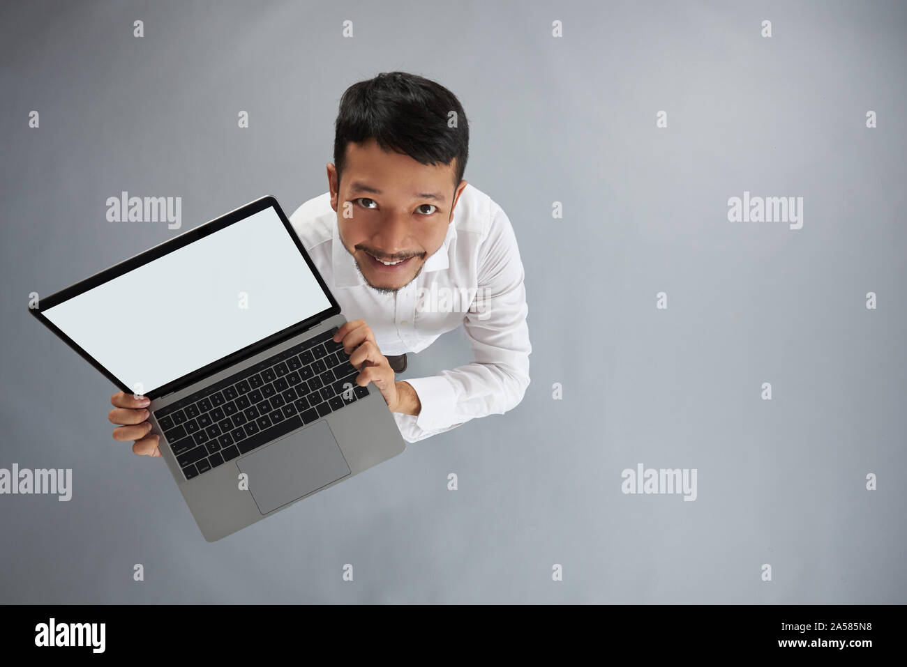 Young man hold laptop above top view on gray studio background Stock ...