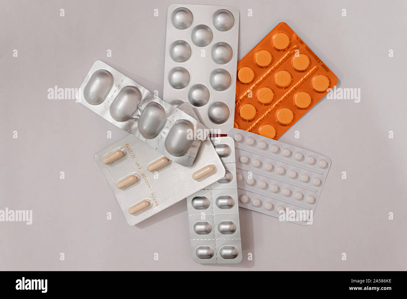 pill tablets of different colors, materials and sizes laying on a white ...