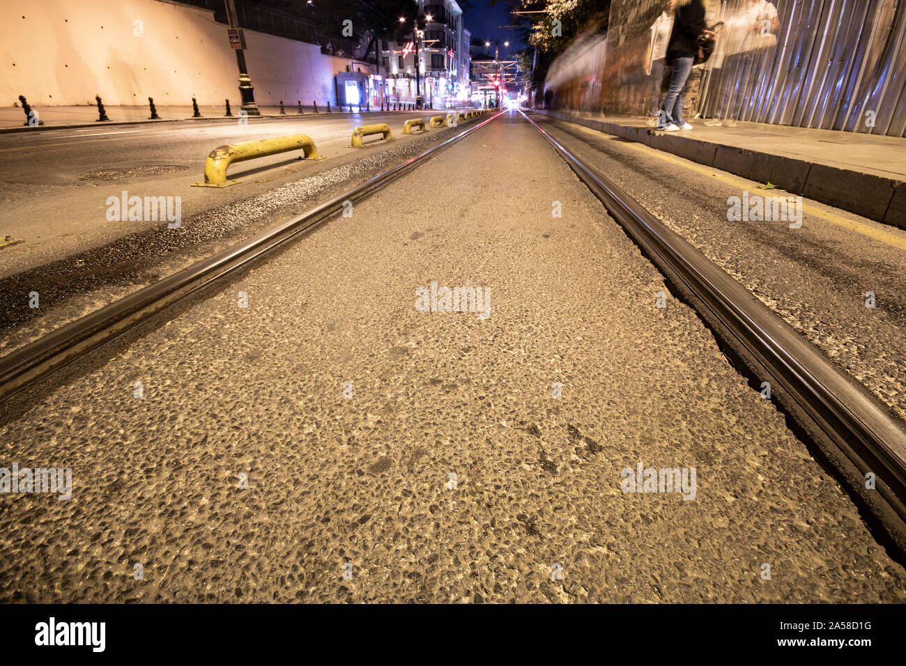 Tram rails on asphalt. People walking and traffic lights on the ...