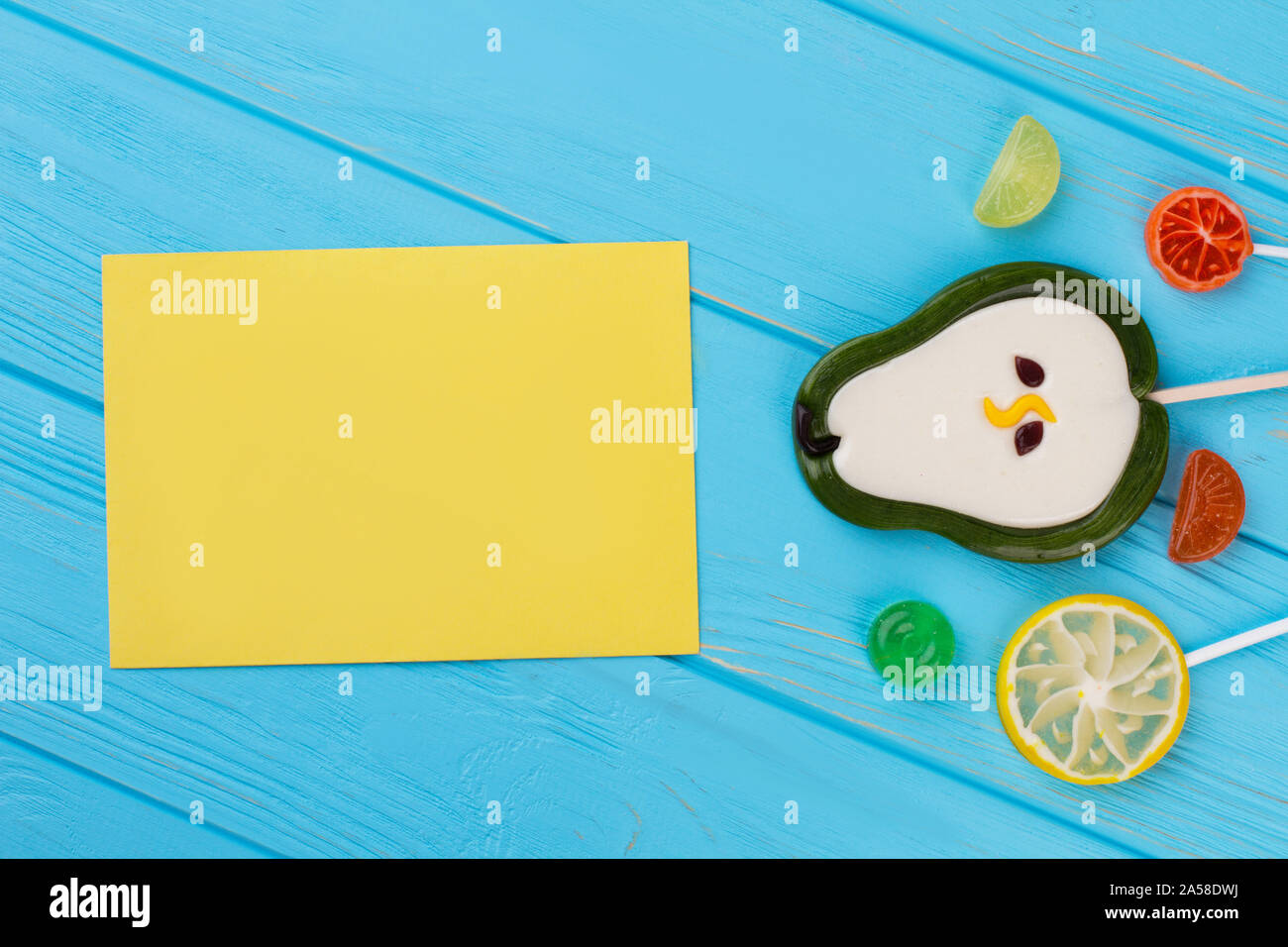 Colorful lollipops and yellow paper sheet Stock Photo - Alamy