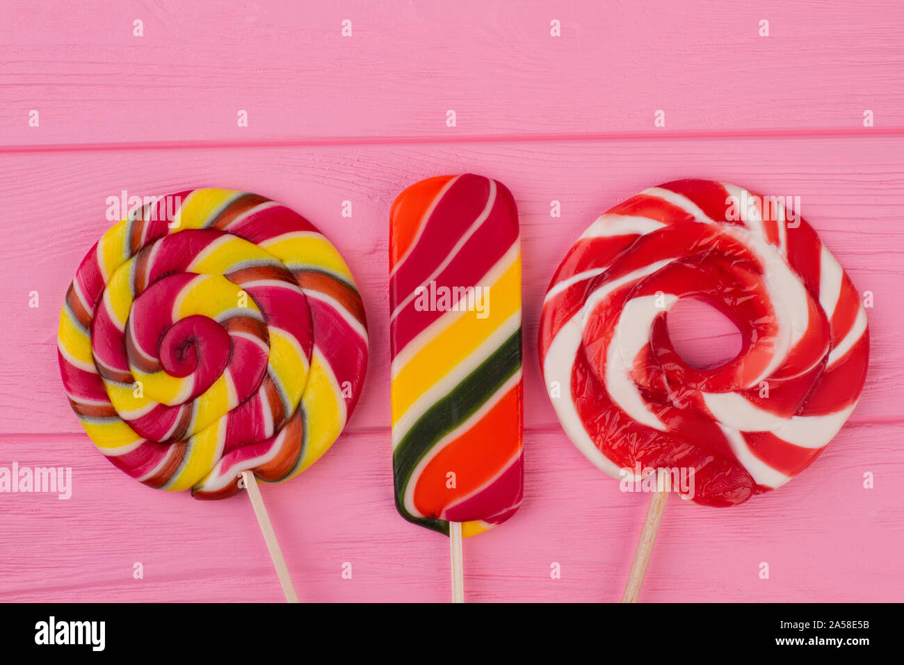 Three big striped lollipops on color background Stock Photo - Alamy