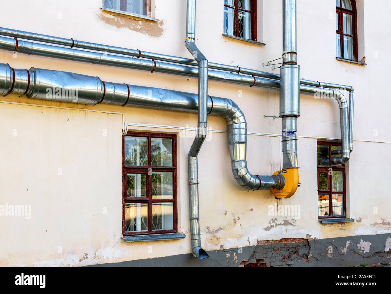 Metal pipes for ventilation and water mounted on the wall of building ...