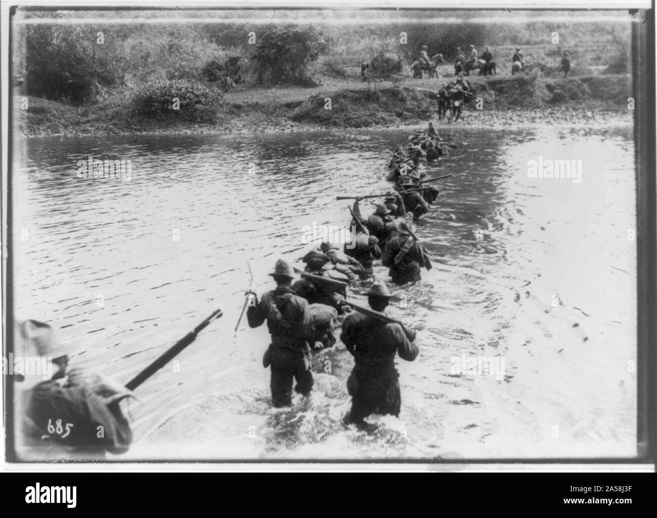 U.S. soldiers fording river during Philippine Insurrection. 1899 Stock ...