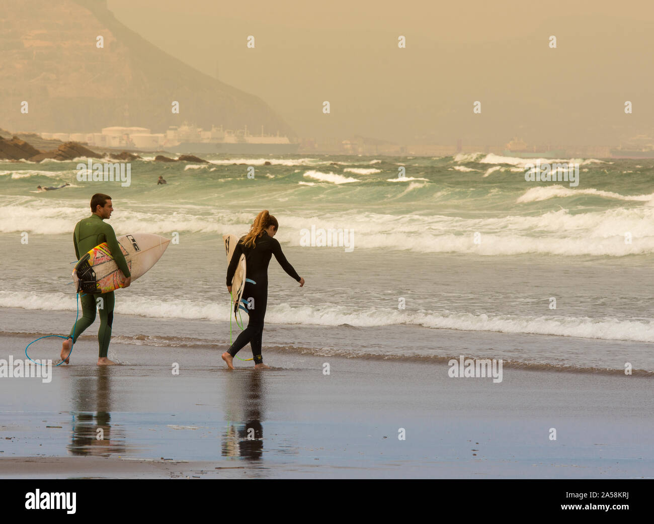 Surfers walking in the beach in basque country Stock Photo - Alamy