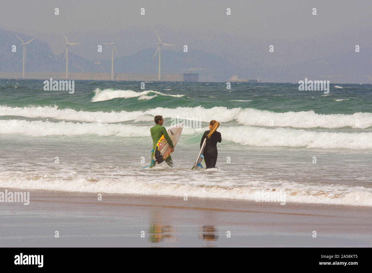 Surfers walking in the beach in basque country Stock Photo - Alamy