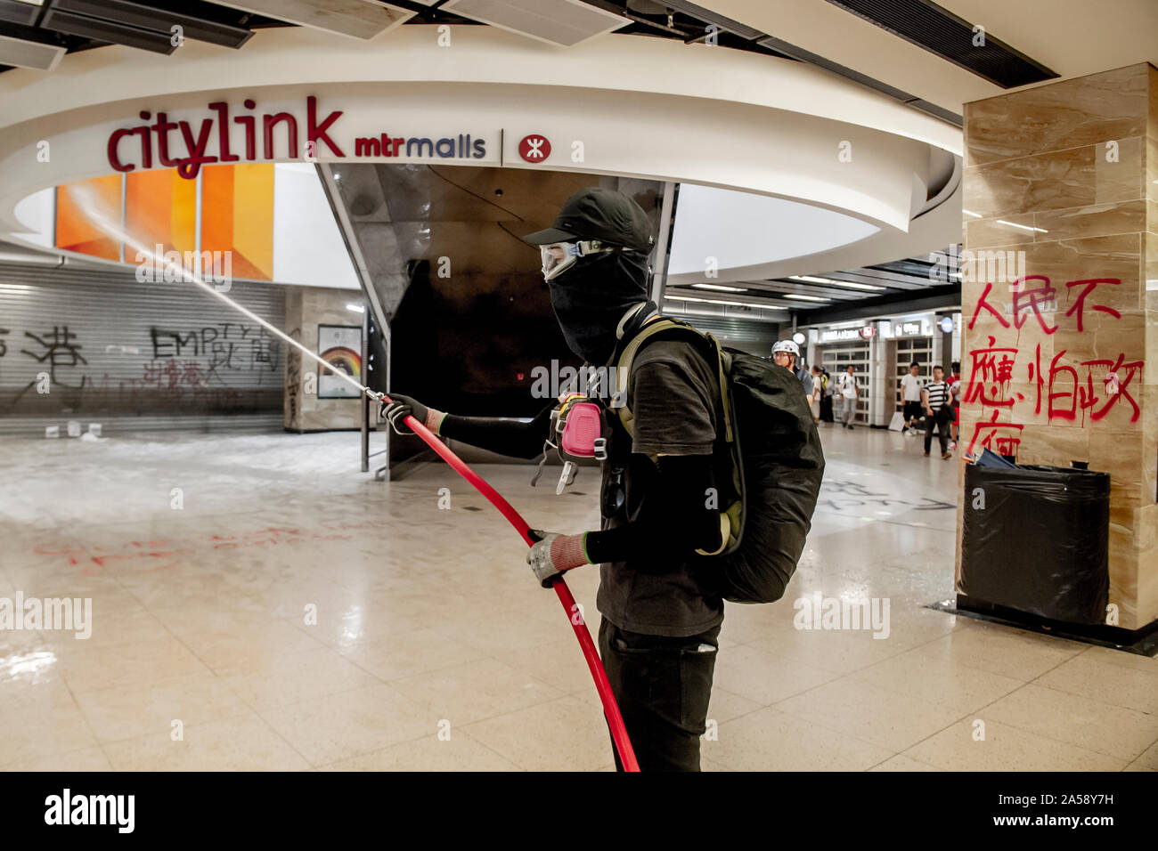 Hong Kong protestors, having prised open a cupboard with a fire hose ...