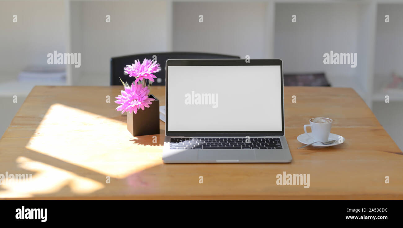 Open blank screen laptop computer in comfortable workspace with pink ...