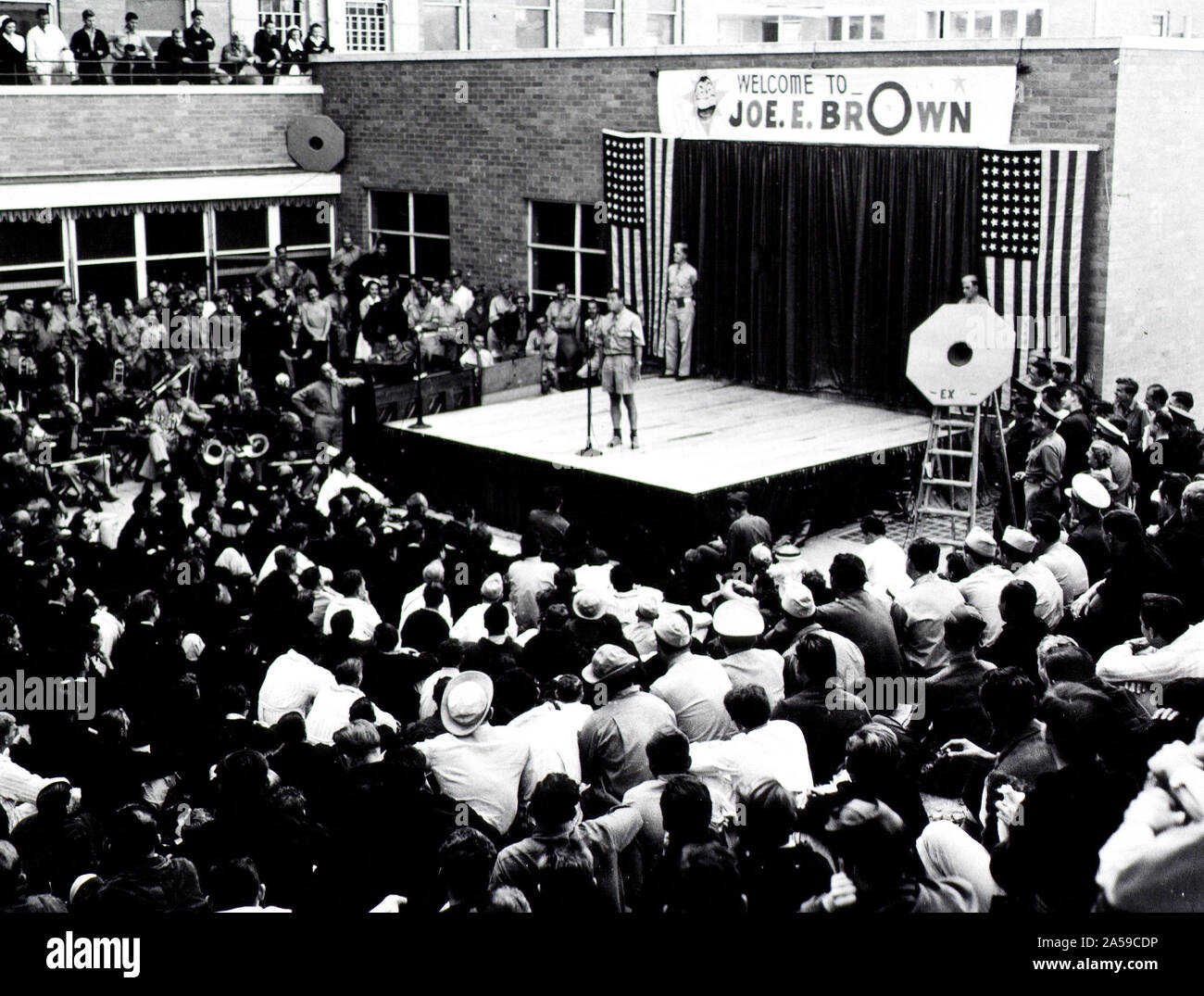 Aerial view of a performance given by Joe E. Brown. Brown stands at a ...