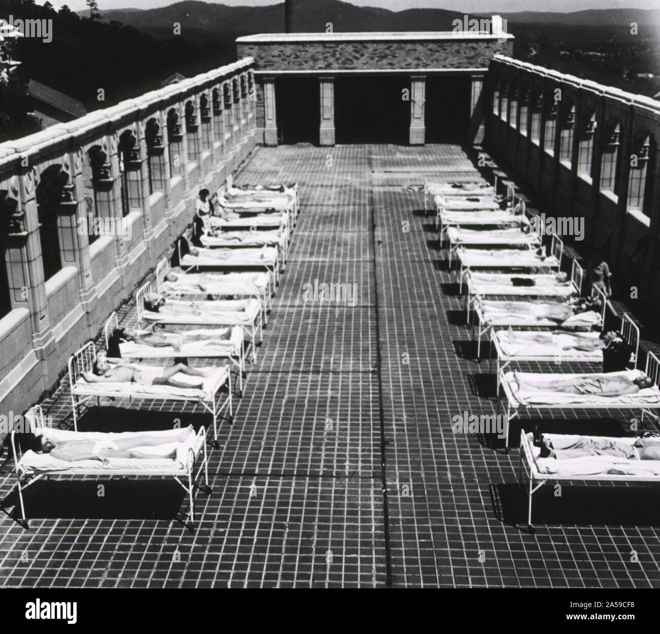 Bird's-eye view of a rooftop deck. A row of hospital beds line each ...