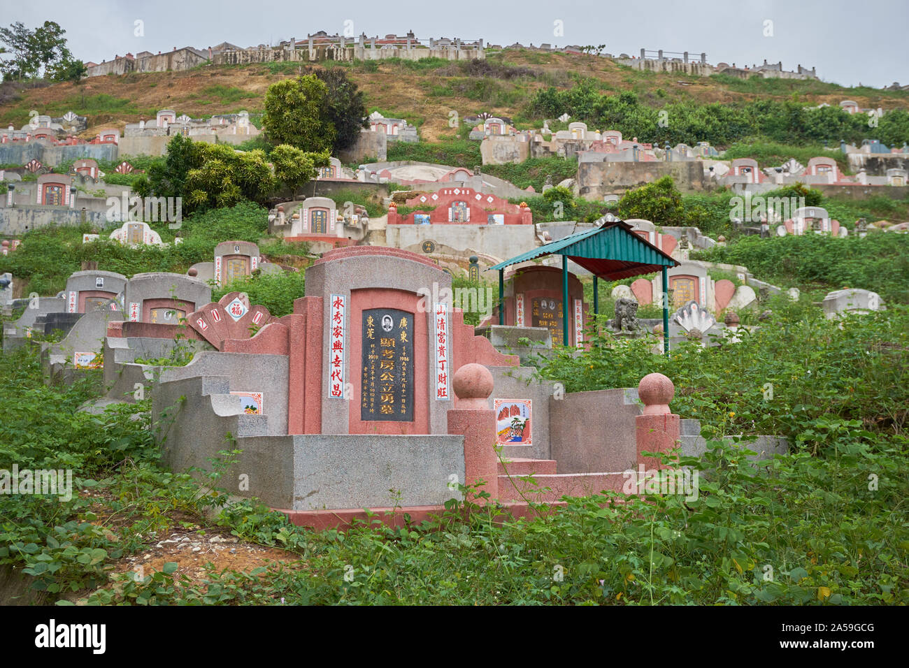 A view of a large, Chinese cemetery on a steep hillside. In Kuala Lipis ...