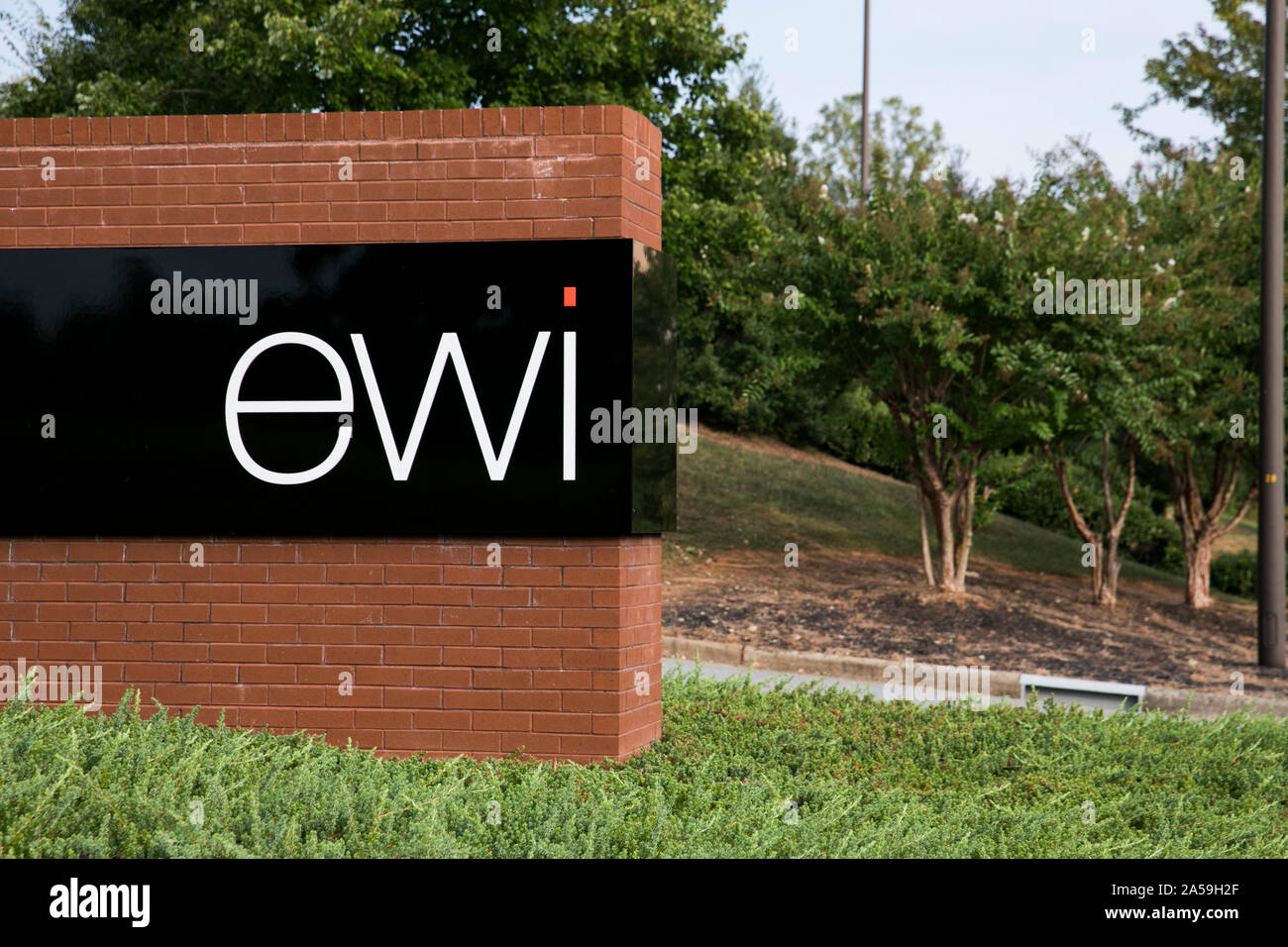 A logo sign outside of a facility occupied by EWI Worldwide in Winston ...