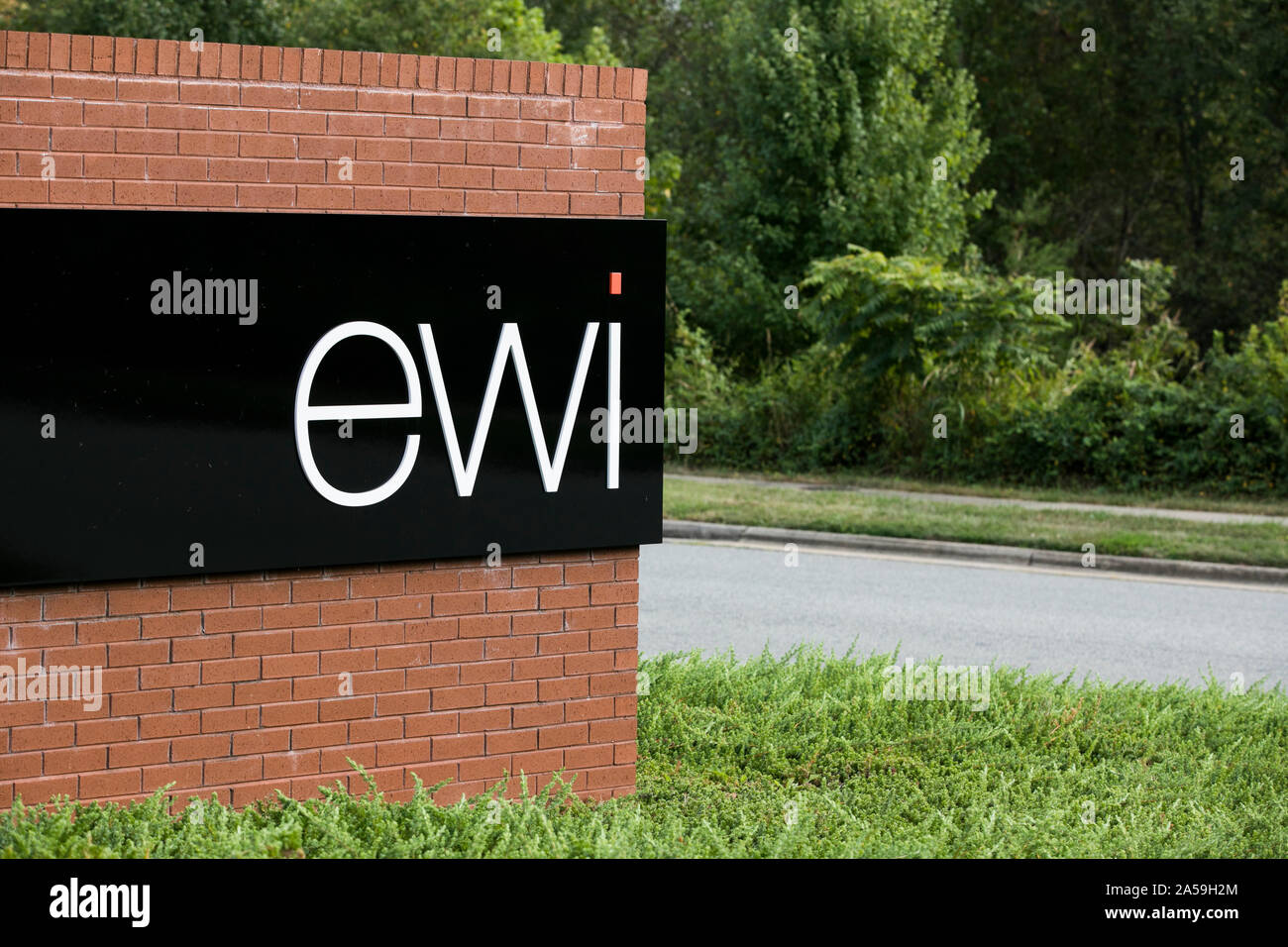 A logo sign outside of a facility occupied by EWI Worldwide in Winston ...