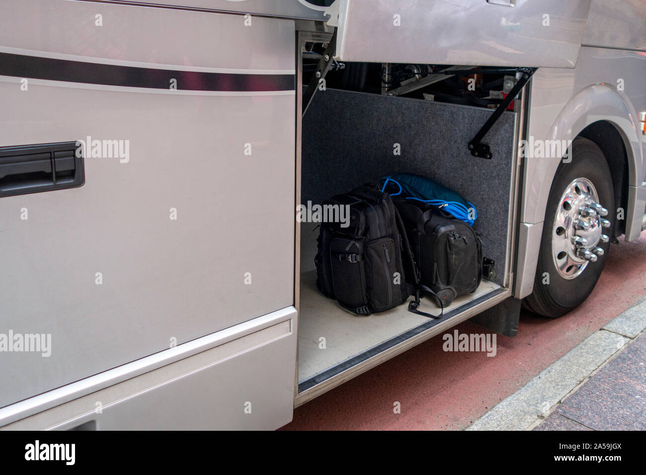 large silver transit shuttle bus with open side baggage compartment ...