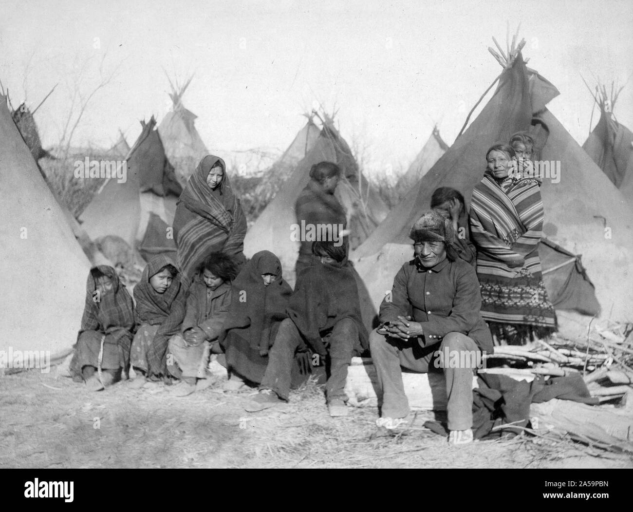 Group of eleven Miniconjou (children and adults) in a tipi camp ...