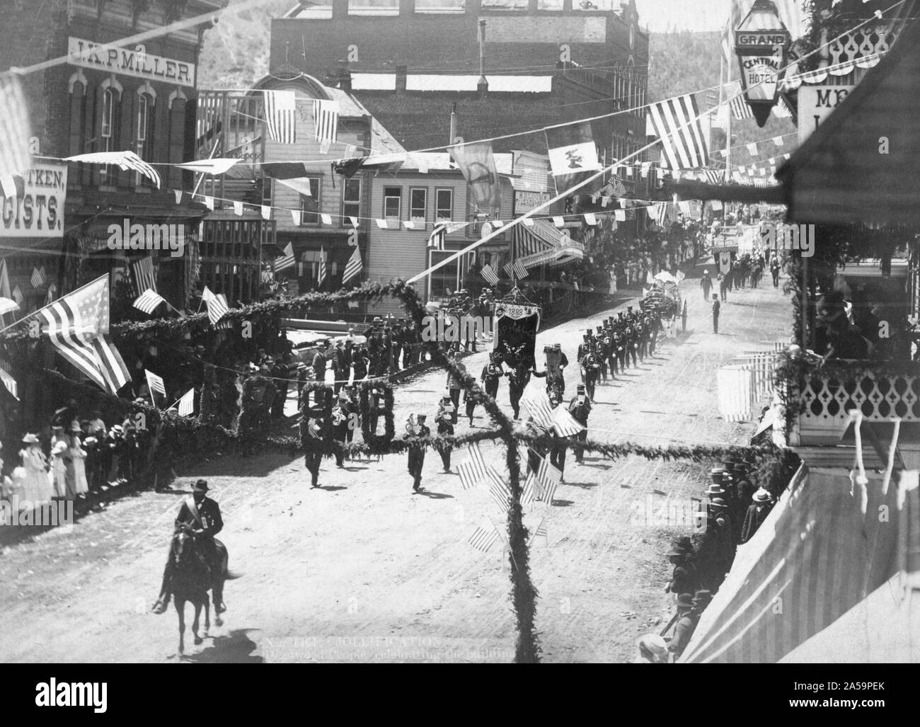 Street parade with numbers "1888" and man on horseback in foreground ...