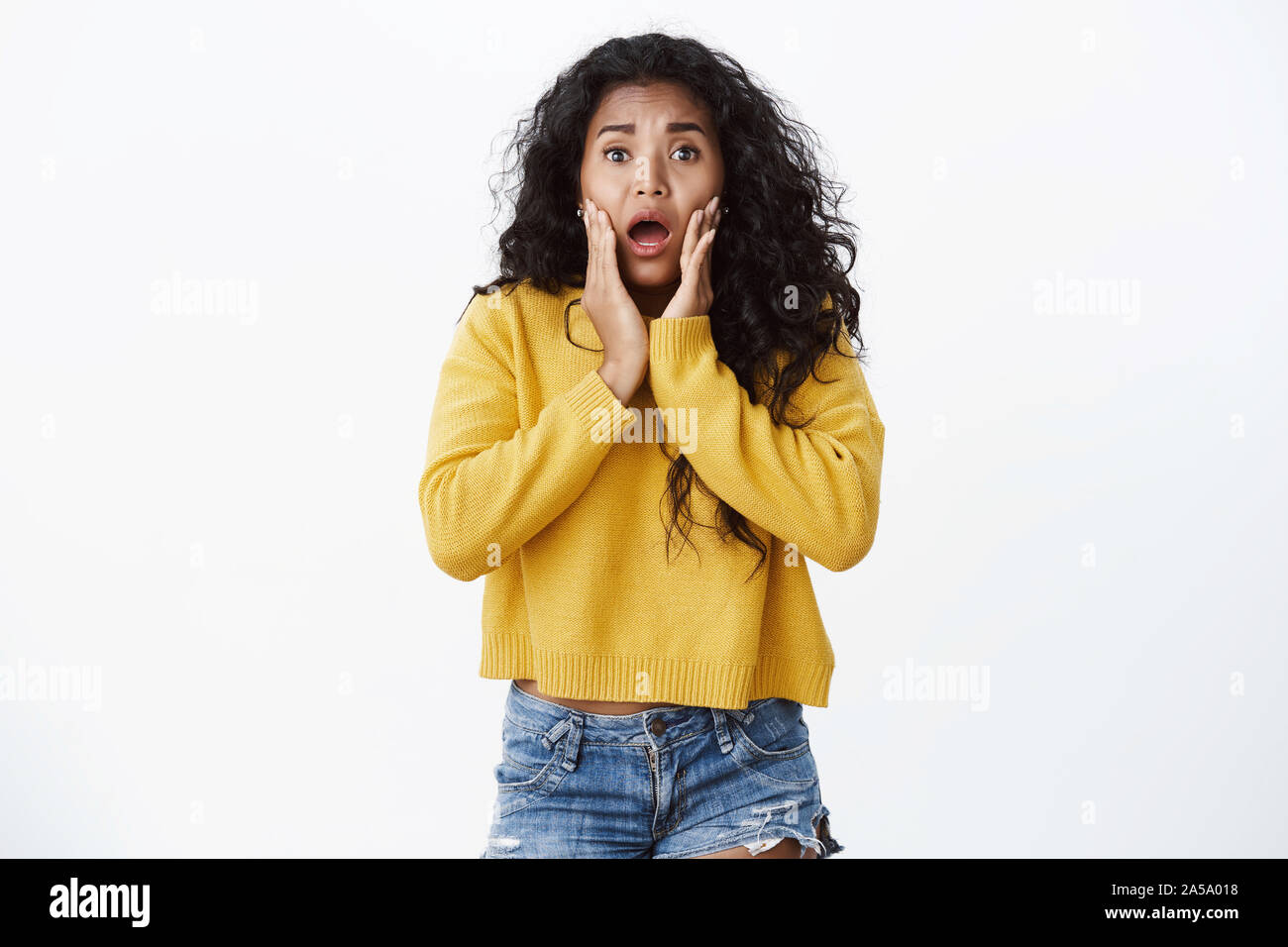 Shocked and alarmed, worried curly-haired african american woman in ...