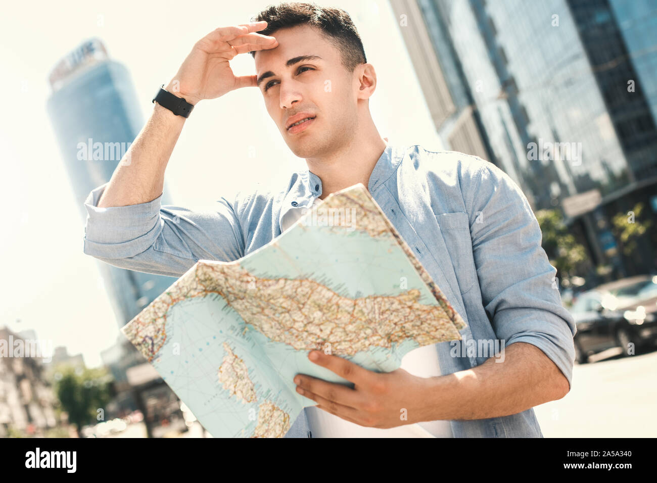Outdoors Leisure. Stylish guy traveler standing on the street with map ...