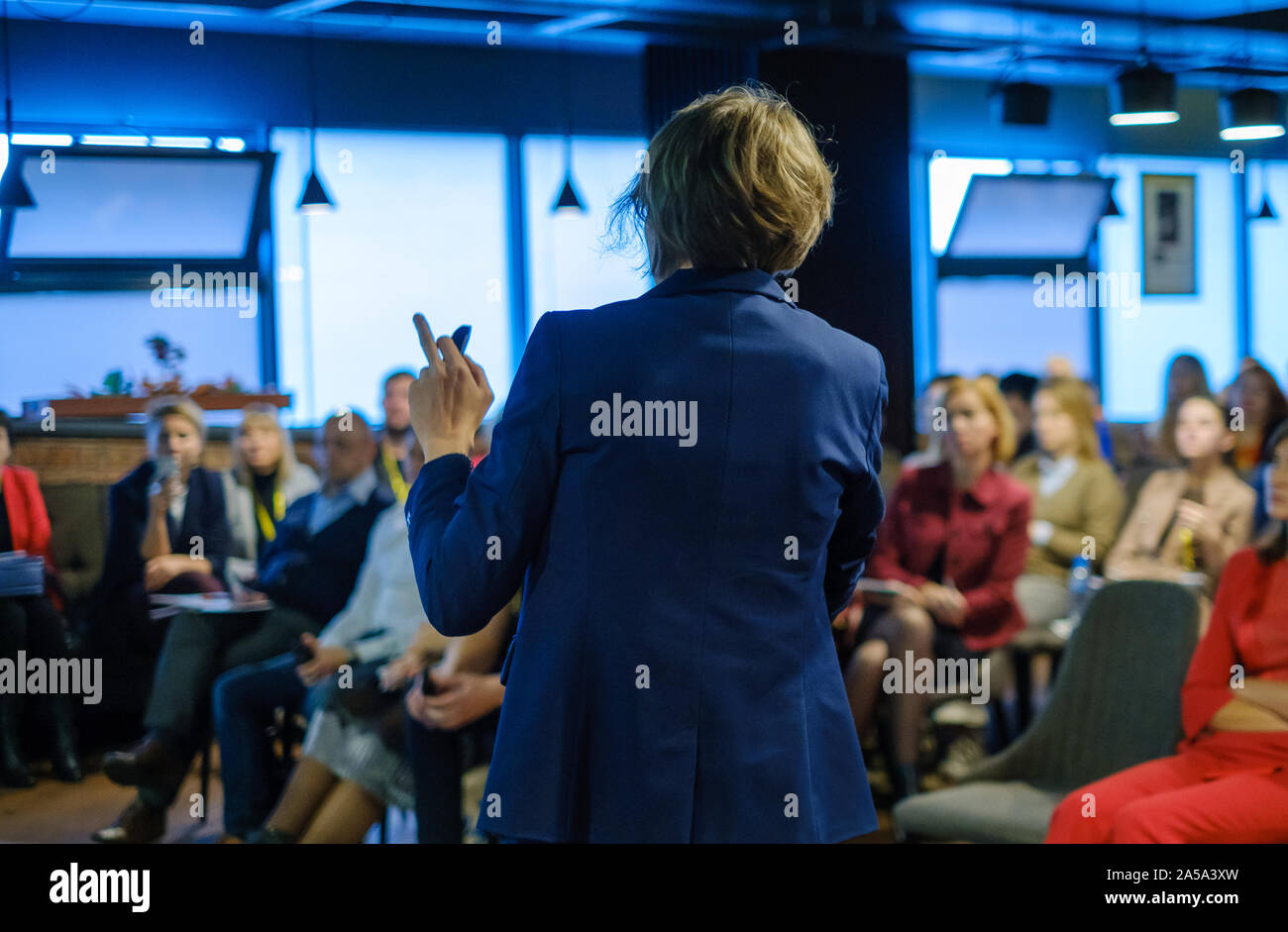 Female presenter speaks to audiences at workshop Stock Photo - Alamy