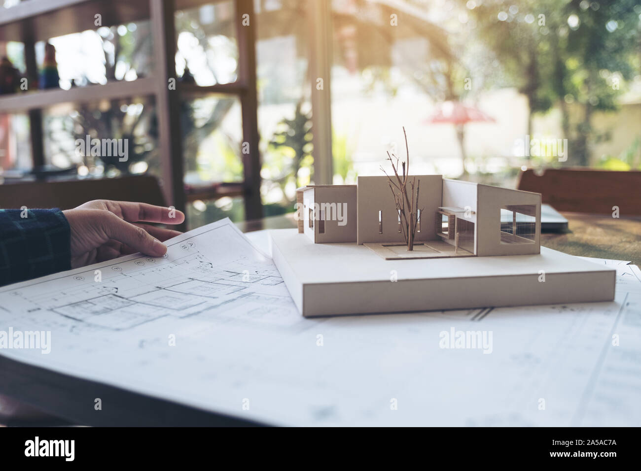 An architect working on an architecture model with shop drawing paper ...