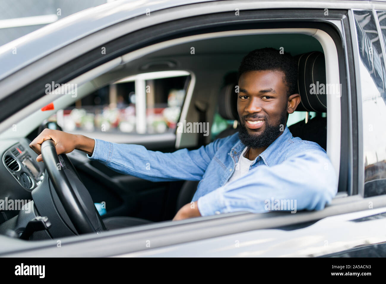 Young affluent successful businessman driving his new expensive car ...